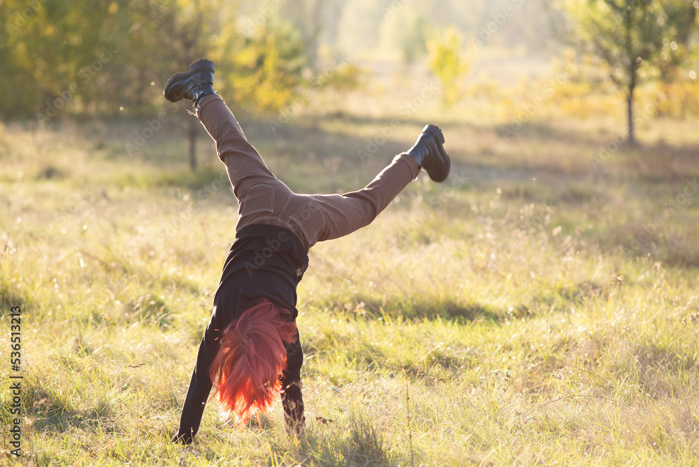 School holidays and weekends. A child with red hair somersaults jump ...