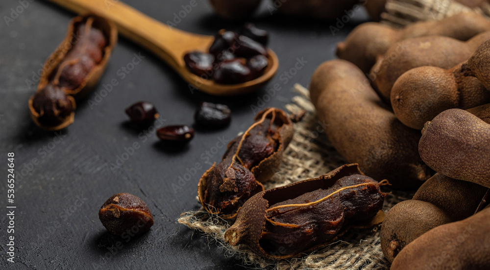 Tropical fruits, Tamarindo beans in shell on a brown butchers block on ...