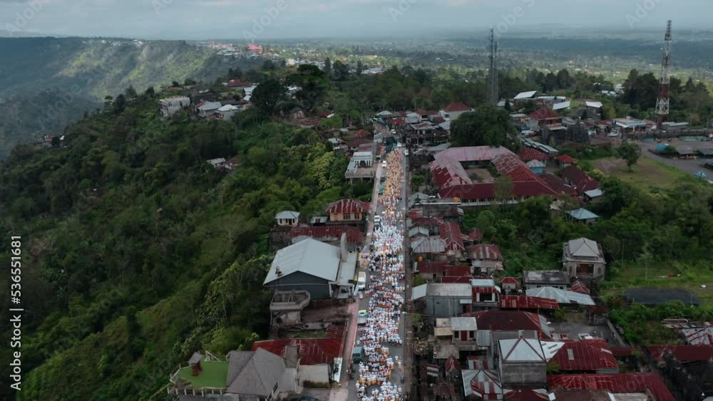 Hindu ceremony parade making a traffic jam in the street. Aerial view of procession of ...