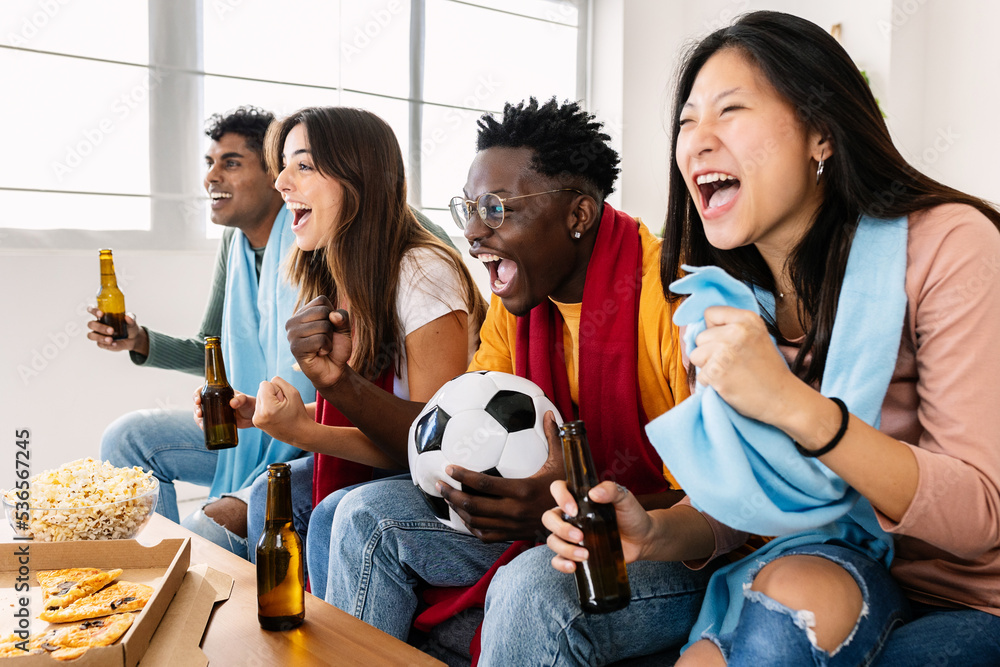 Multi ethnic young football fans people screaming and supporting their ...