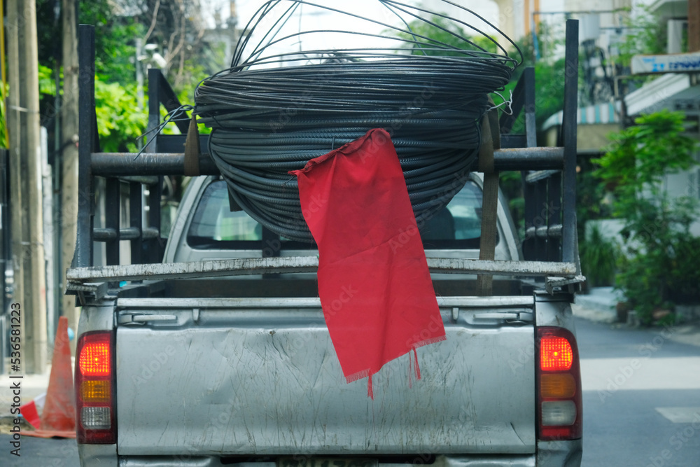 A red flag is tied to the back of a pickup truck. Stock Photo | Adobe Stock