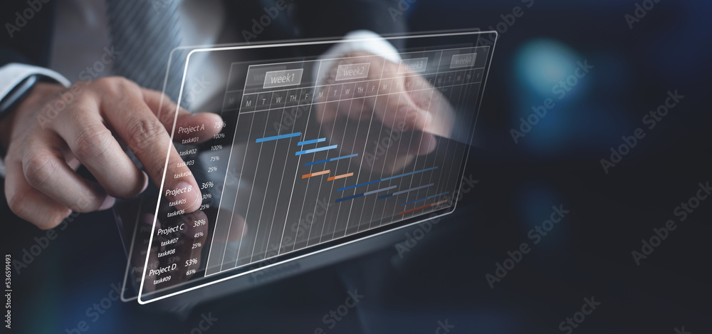 Project manager working on digital tablet and updating tasks with ...