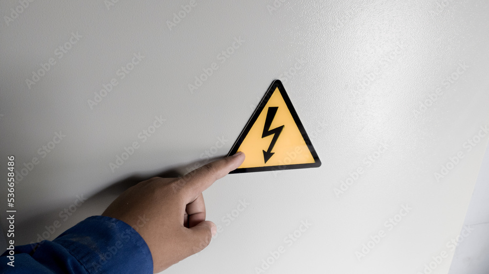 The male hand is pointing at the warning symbol image there is an ...