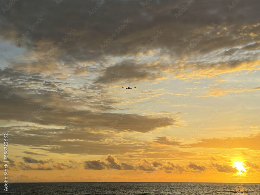 Beautiful sunset above the sea. Clouds and bright orange sun glow on ...