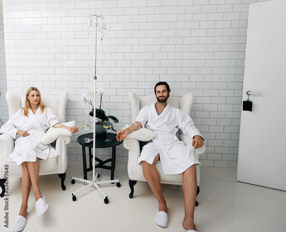 Beautiful couple during intravenous vitamin therapy to boosting the ...