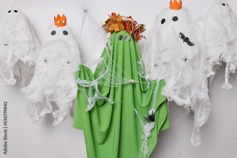 Horizontal shot of creepy ghost covered with green sheet prepares for ...