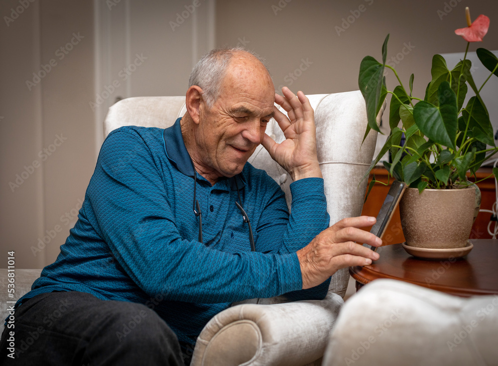 healthy senior man in his mid-70s looking at messages and pictures on ...
