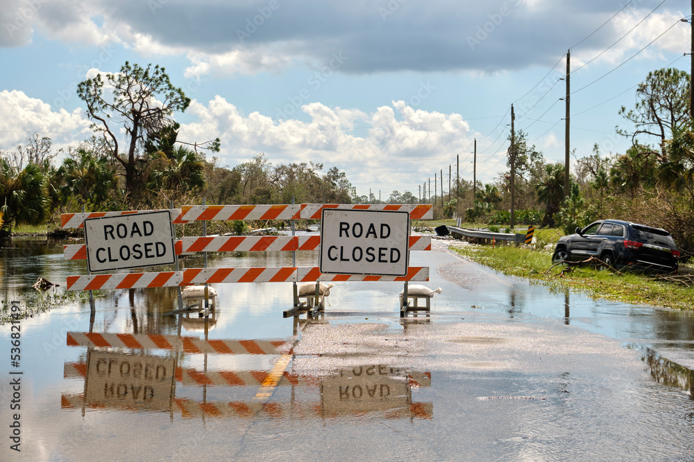 Road closed for roadworks and danger of flooding with warning signs ...