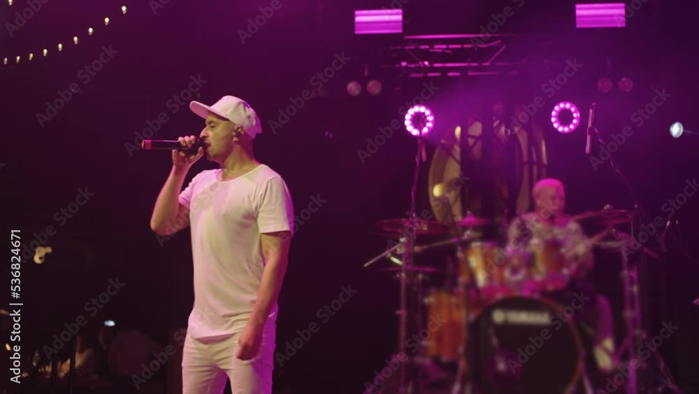 cool rapper is singing and jumping on stage, concert of popular ...