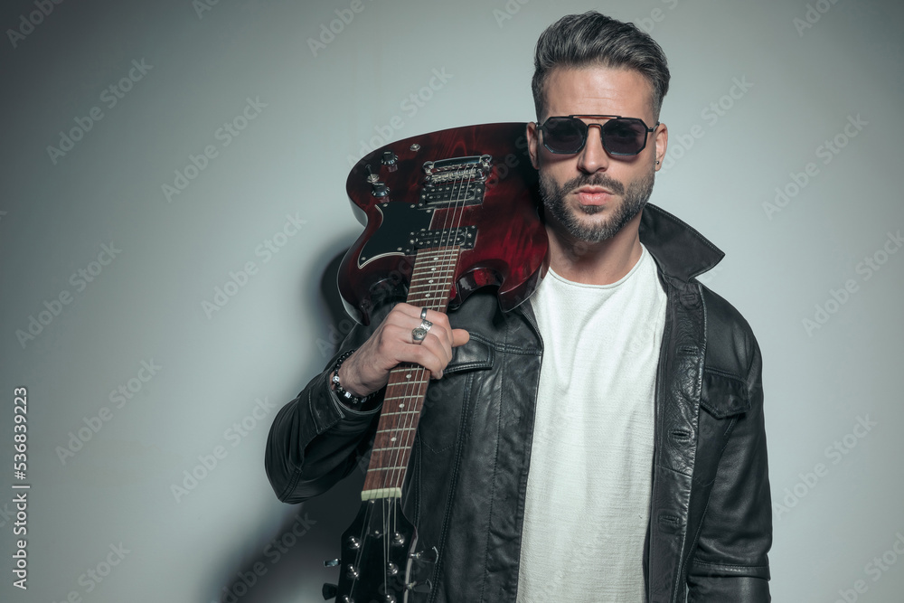 rocker wearing a black leather jacket and sunglasses Stock Photo ...