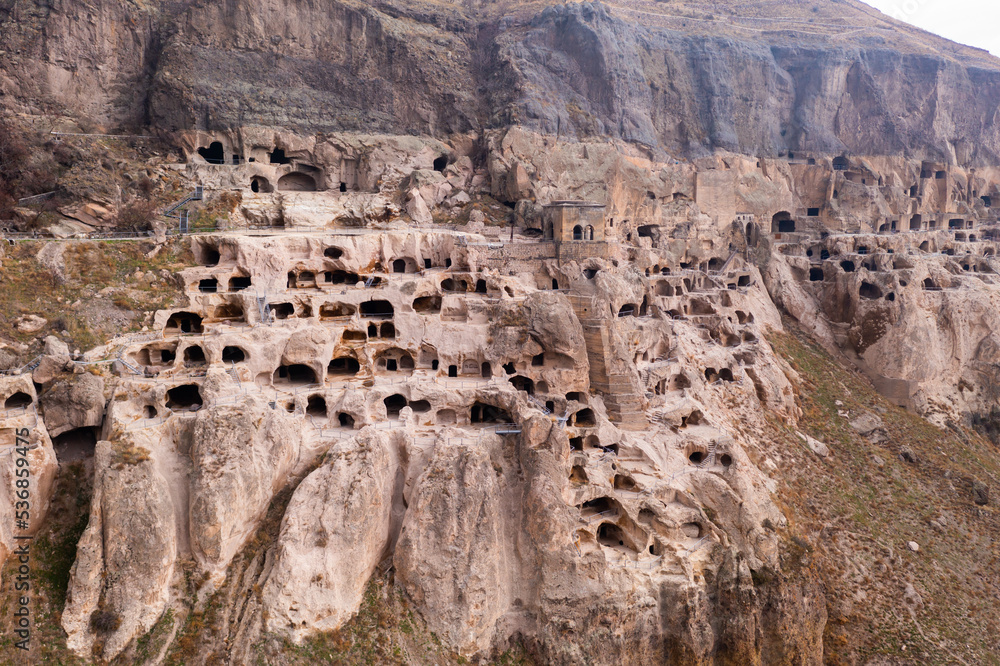 Complex of cave monastery structures carved into mountain in historic ...