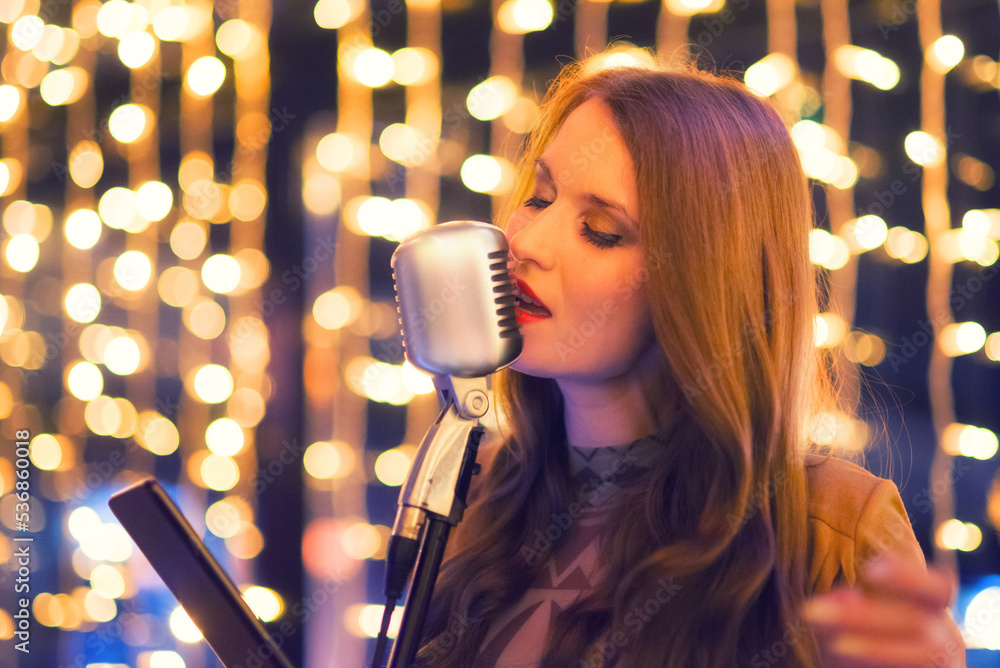Female singer singing on the concert with her band on the restaurant ...