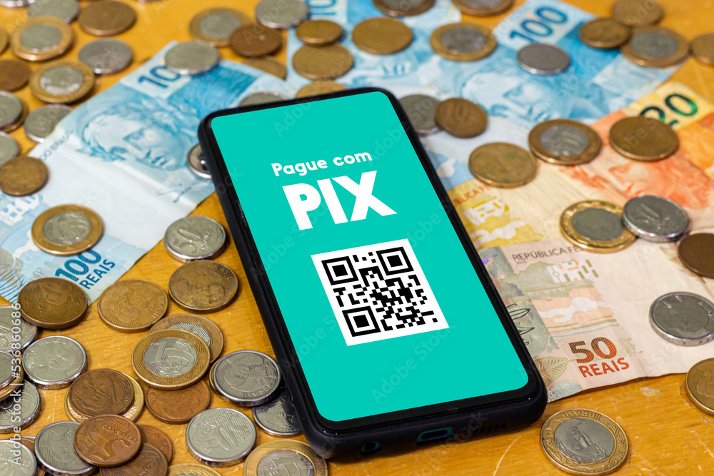 Pix on smartphone screen with multiple coins around. Pix is the new ...