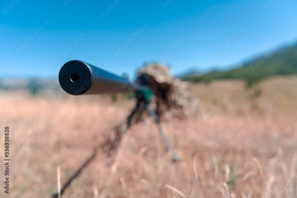 army soldier holding sniper rifle with scope and aiming in forest. war ...