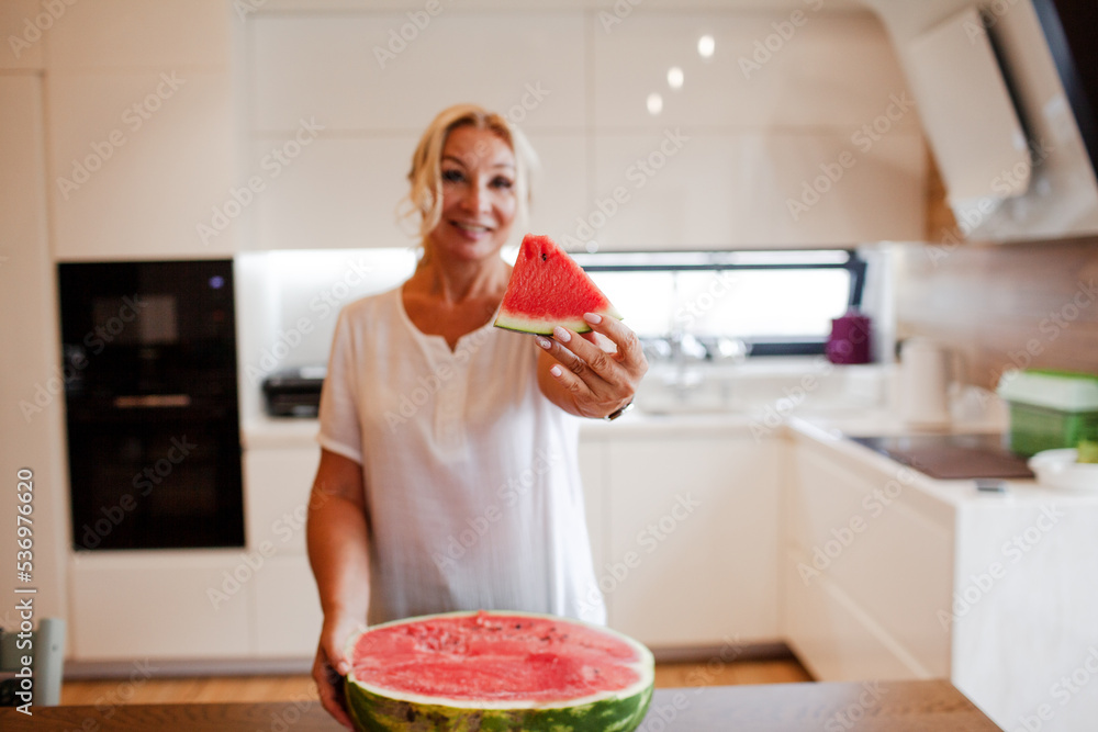 Middle- aged woman cooking in the kitchen at home. 60s year old woman ...