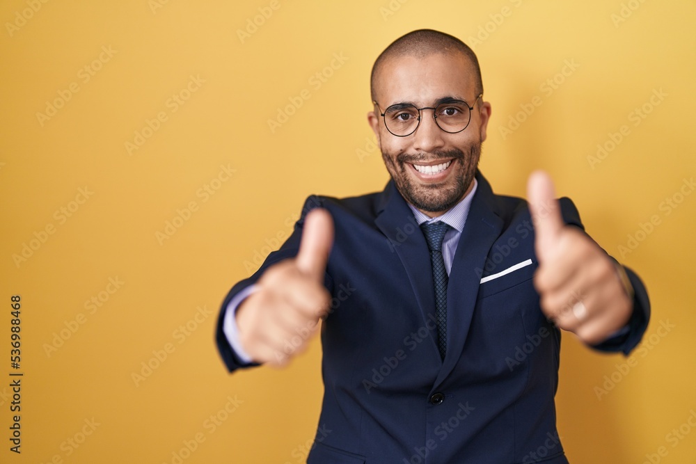 Hispanic man with beard wearing suit and tie approving doing positive ...