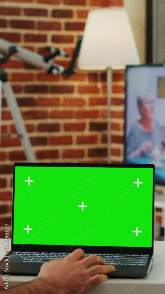 Vertical video: Modern manager looking at laptop with greenscreen ...