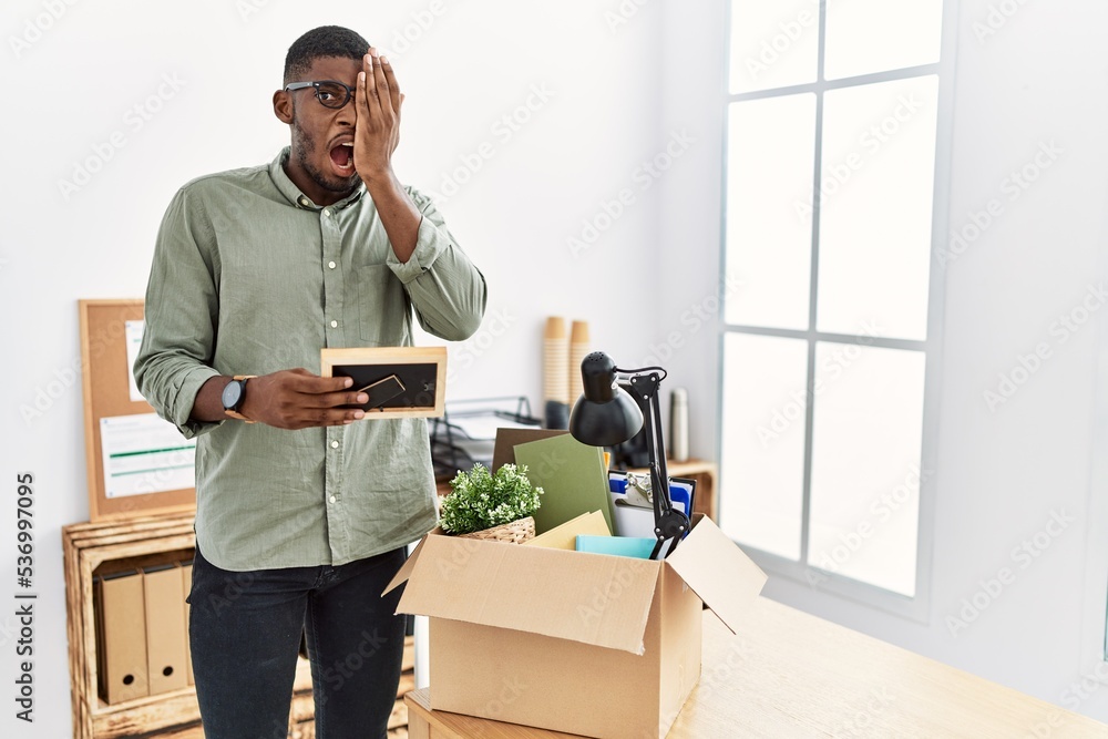 Young african american businessman unboxing box at the office yawning ...