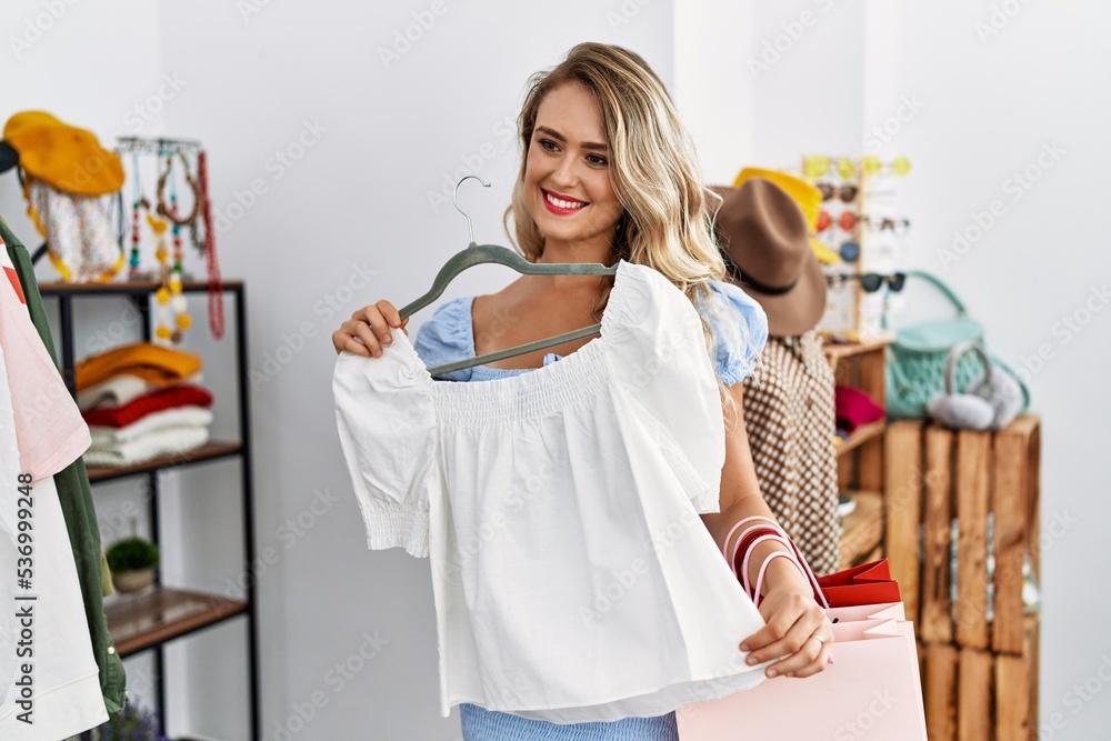 Young woman customer holding shirt shopping at clothing store Stock ...