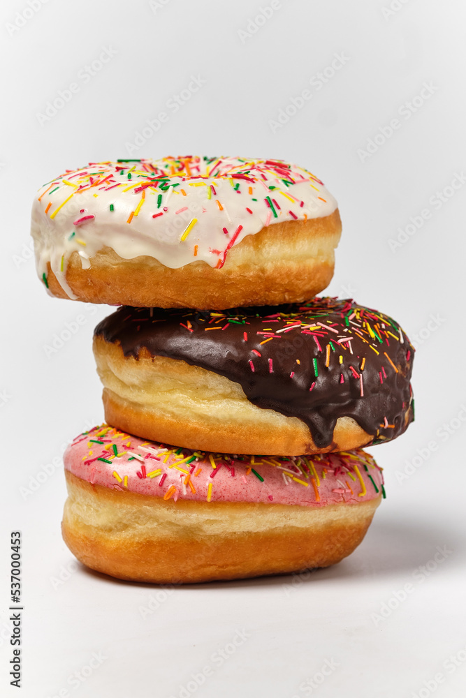 three donuts with different types of glaze on top of each other on a ...