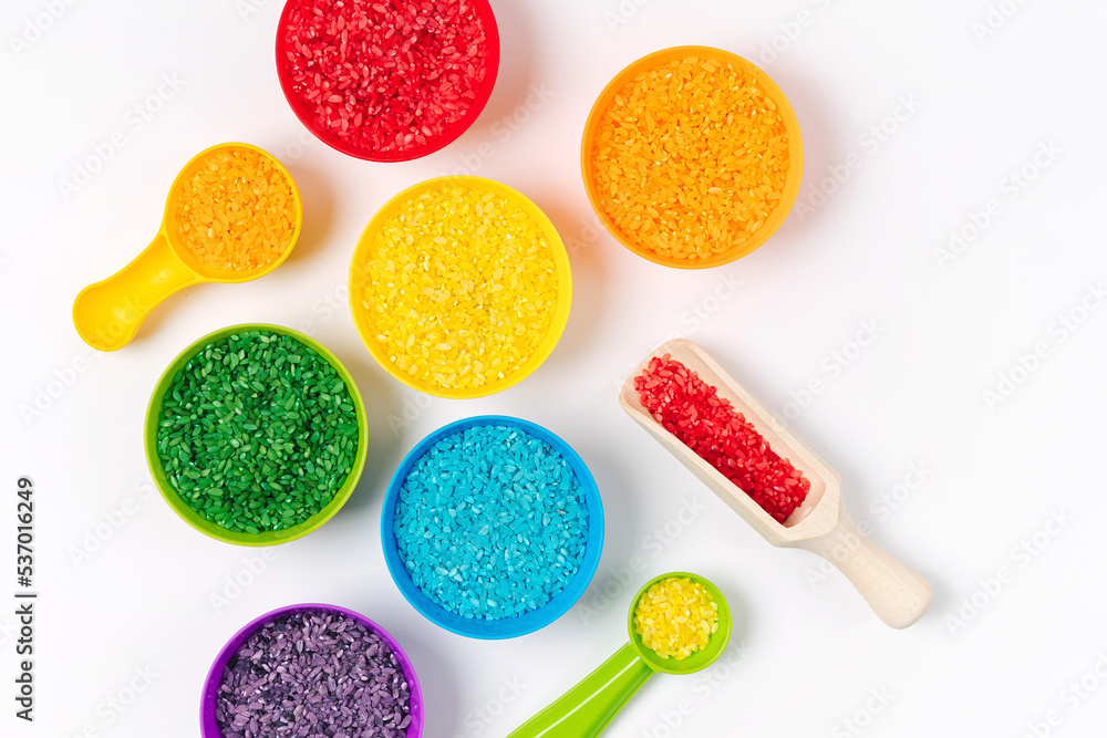 Bowls in rainbow colors with colored rice and scoops. Sensory bin ...