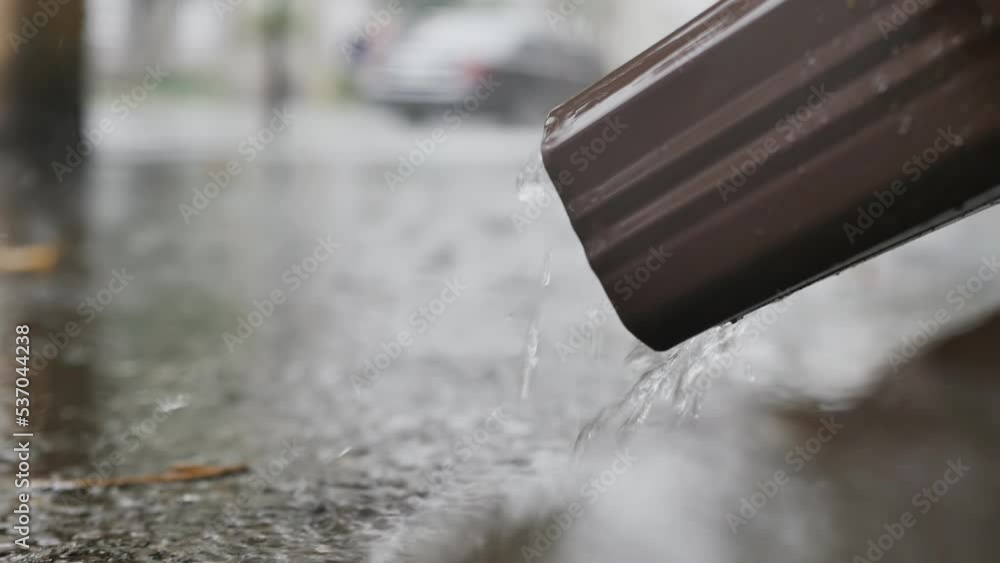 close-up the stream of water flows down the drainpipe from top to ...