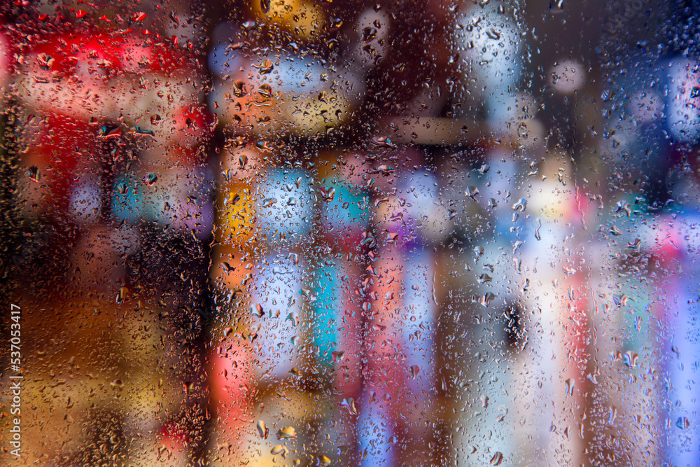 City view through a window on a rainy night,Rain drops on window with ...