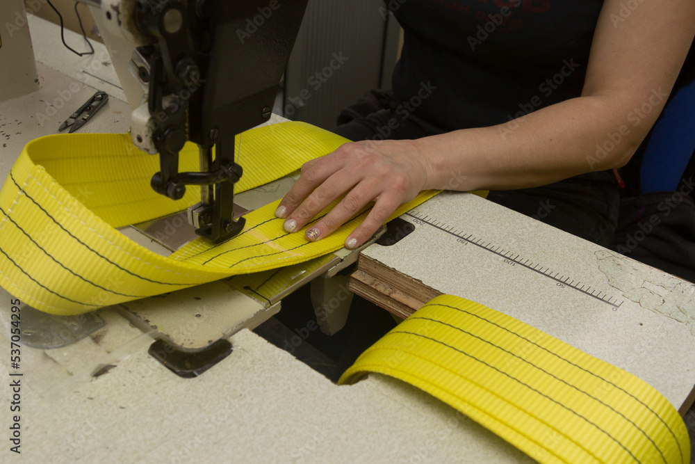 Industrial sewing machine sews a webbing sling. Manufacture of textile ...