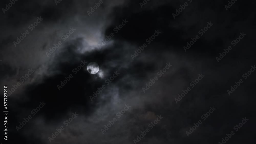 Full moon in the night sky moves through dark clouds, Timelapse. The ...