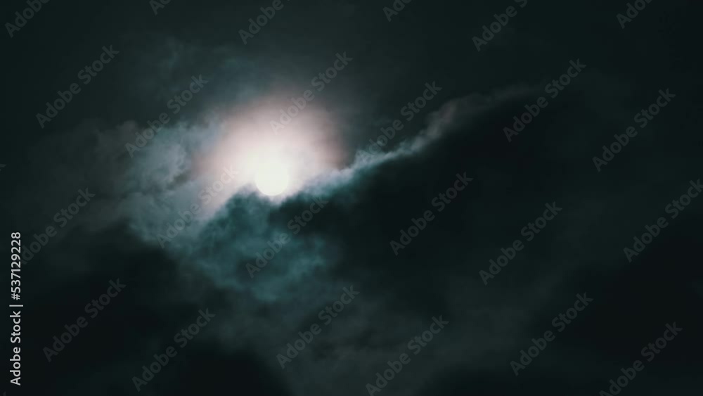Full moon in the night sky moves through dark clouds, Timelapse. The ...