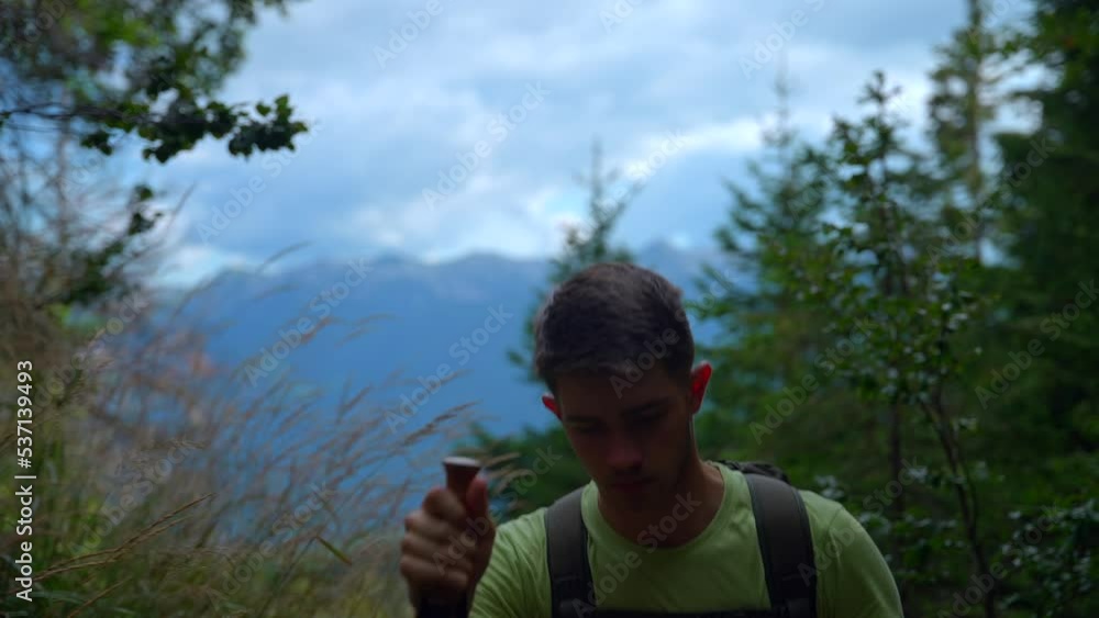 Vidéo Stock Man hiking in forest to the mountain with a backpack ...