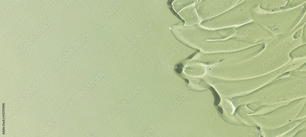 Transparent serum gel with hyaluronic acid for the face on a green ...