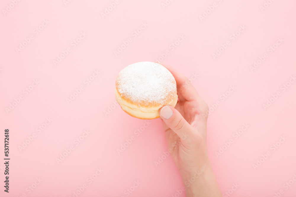 Young adult woman hand holding fresh donut with sprinkled sugar on ...