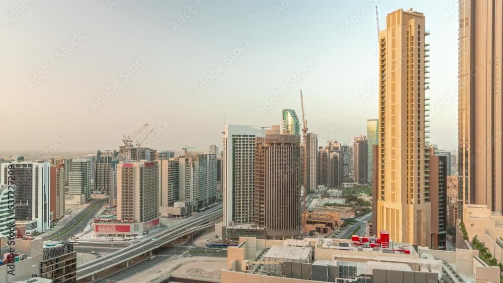 Skyscrapers at the Business Bay in Dubai aerial night to day transition ...