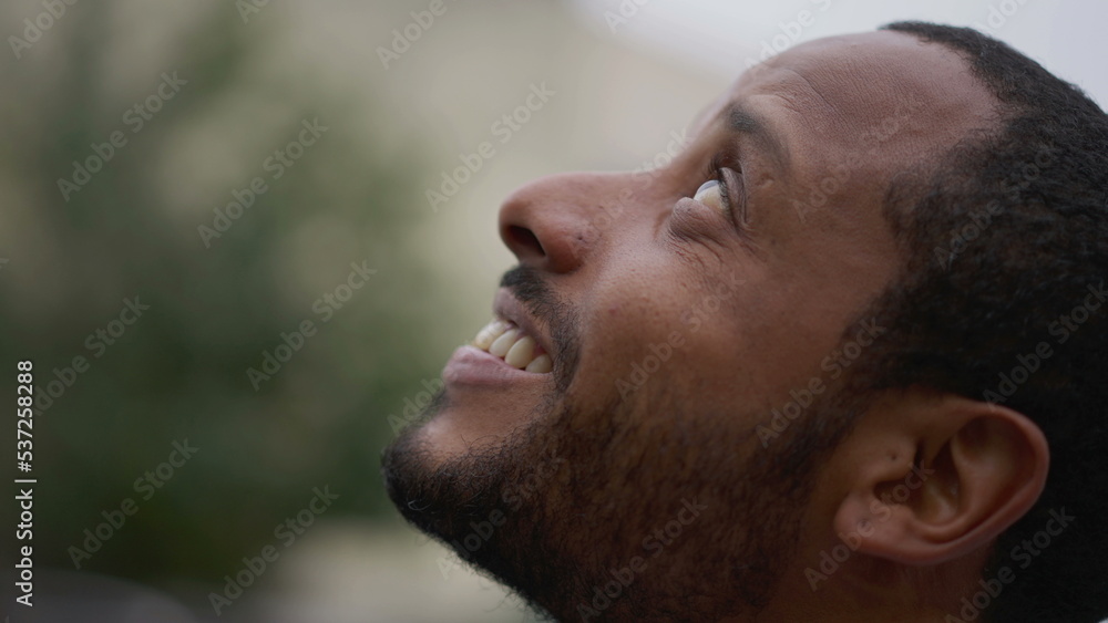 Hopeful African American man closeup face closing eyes in meditation ...