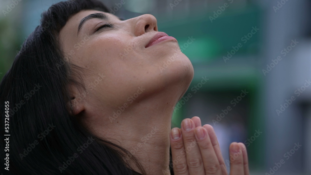 One spiritual young hispanic woman praying to God. Person closing eyes ...