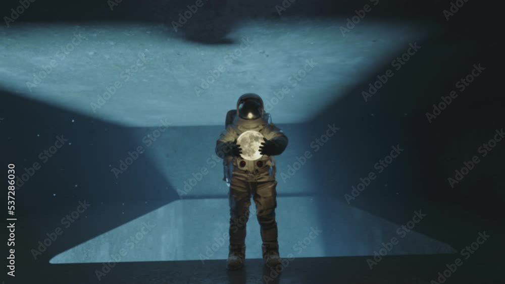 Astronaut in space suit holding the moon, shadows and light moving on ...