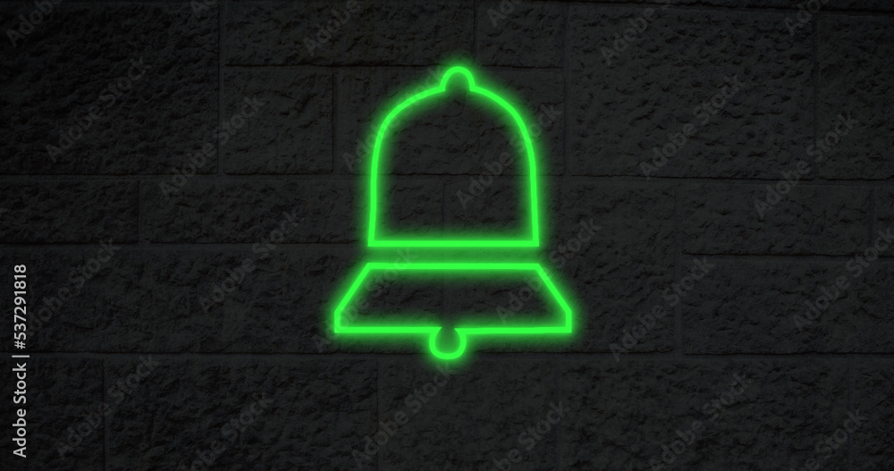Composite of green digital notification bell icon glowing against wall ...