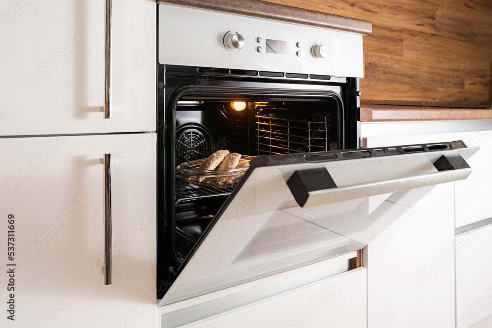 Open door at electric oven with air ventilation. Side view of modern ...