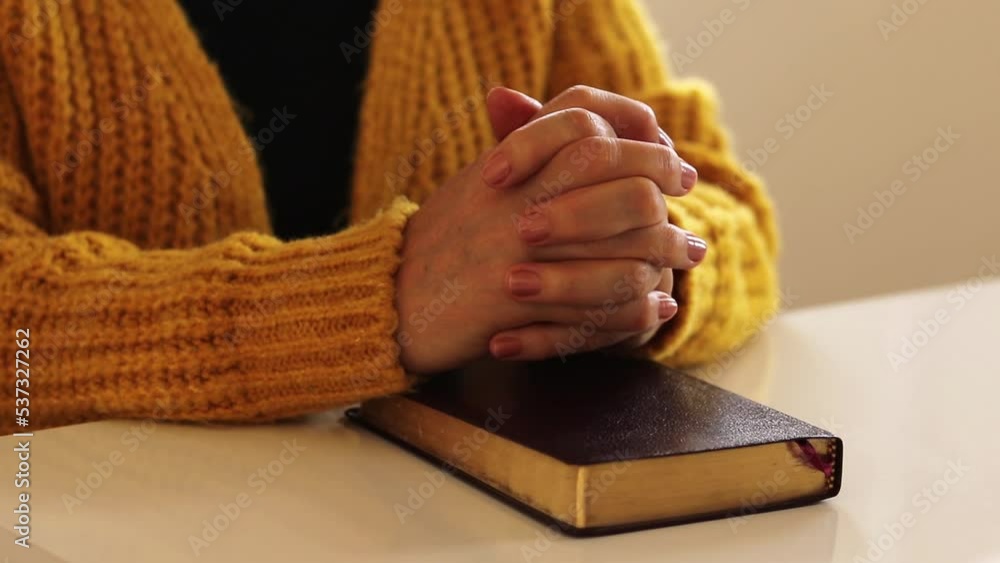 Female clasped hands praying in faith to God Jesus Christ with a Holy ...