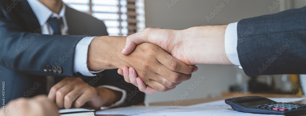 hand of client and banker shaking hands on the meeting table after ...