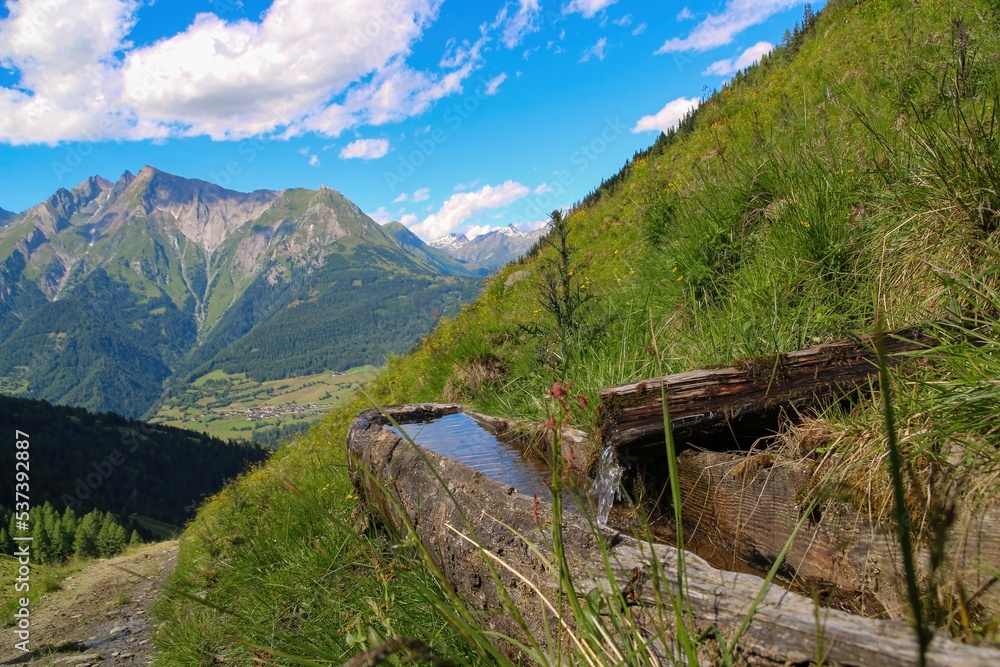Frischwasser-Brunnen einer Alm mit Bergpanorama der Alpen Stock Photo ...