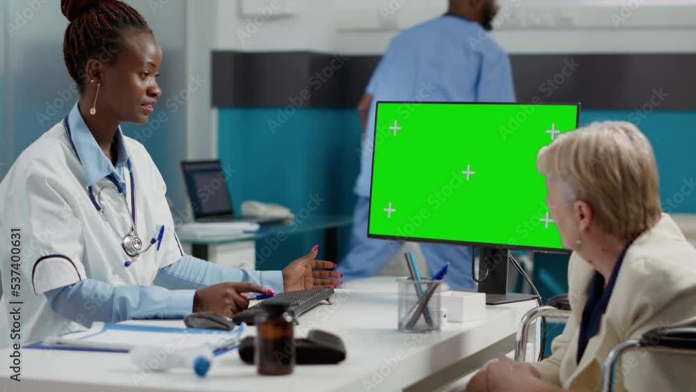 Female medic and paralyzed patient analyzing greenscreen on monitor ...