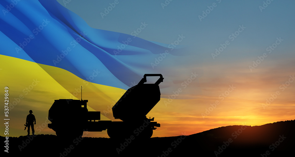Artillery rocket system are aimed to the sky and soldier at sunset with ...