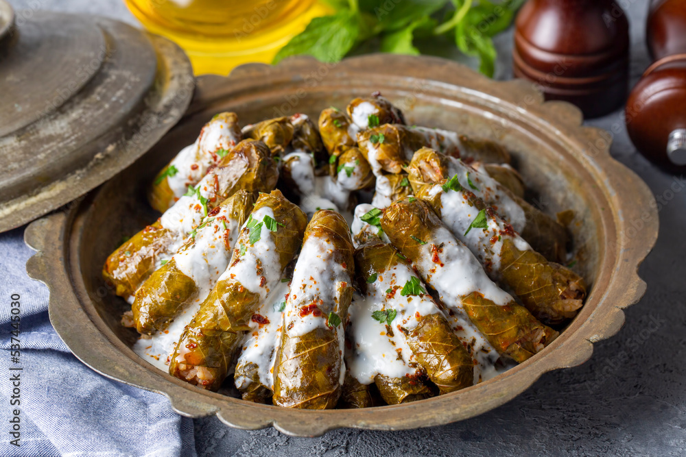 Delicious dolma (sarma) stuffed grape leaves rice, white yogurt sauce. Lebanese dolma sarma on ...