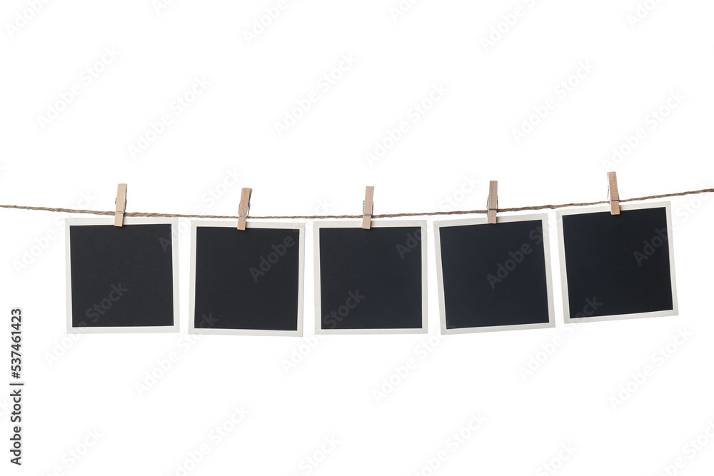 Clothespins with empty instant frames on string against white ...