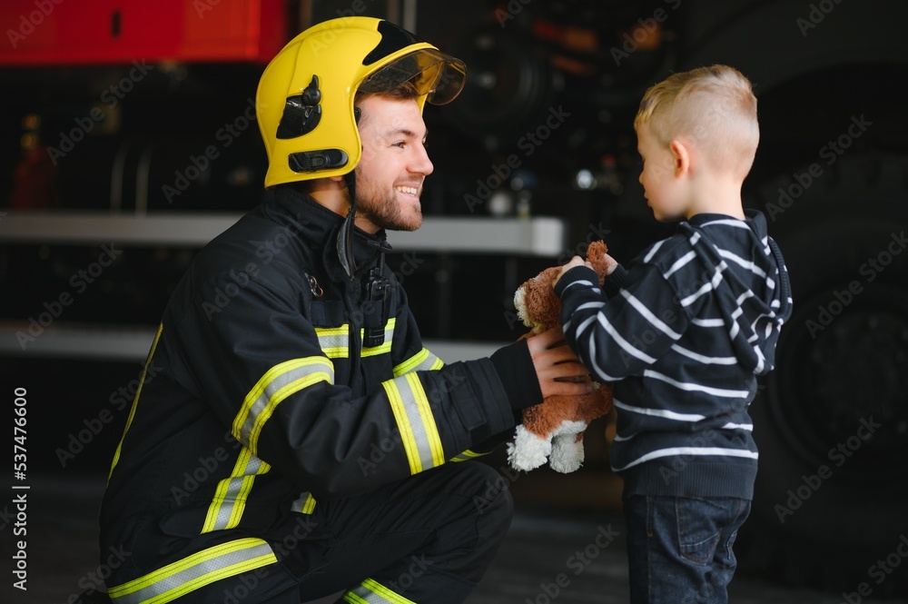 Firefighter holding child boy to save him in fire and smoke,Firemen ...
