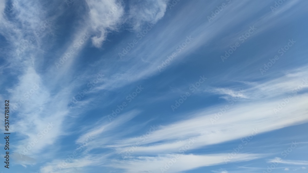 High cirrus clouds in the sky. White elongated translucent clouds hang ...
