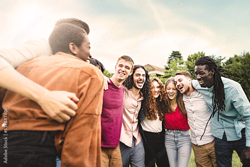 Multiethnic group of joyful young people having fun hugging together ...