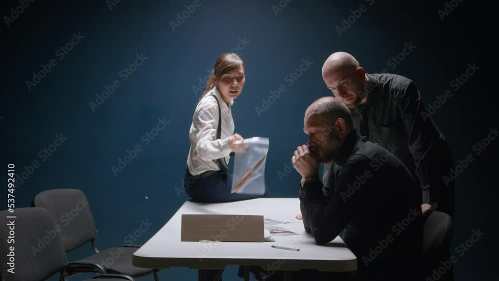 Police interrogation without lawyer. Detective cop shows knife in blood ...